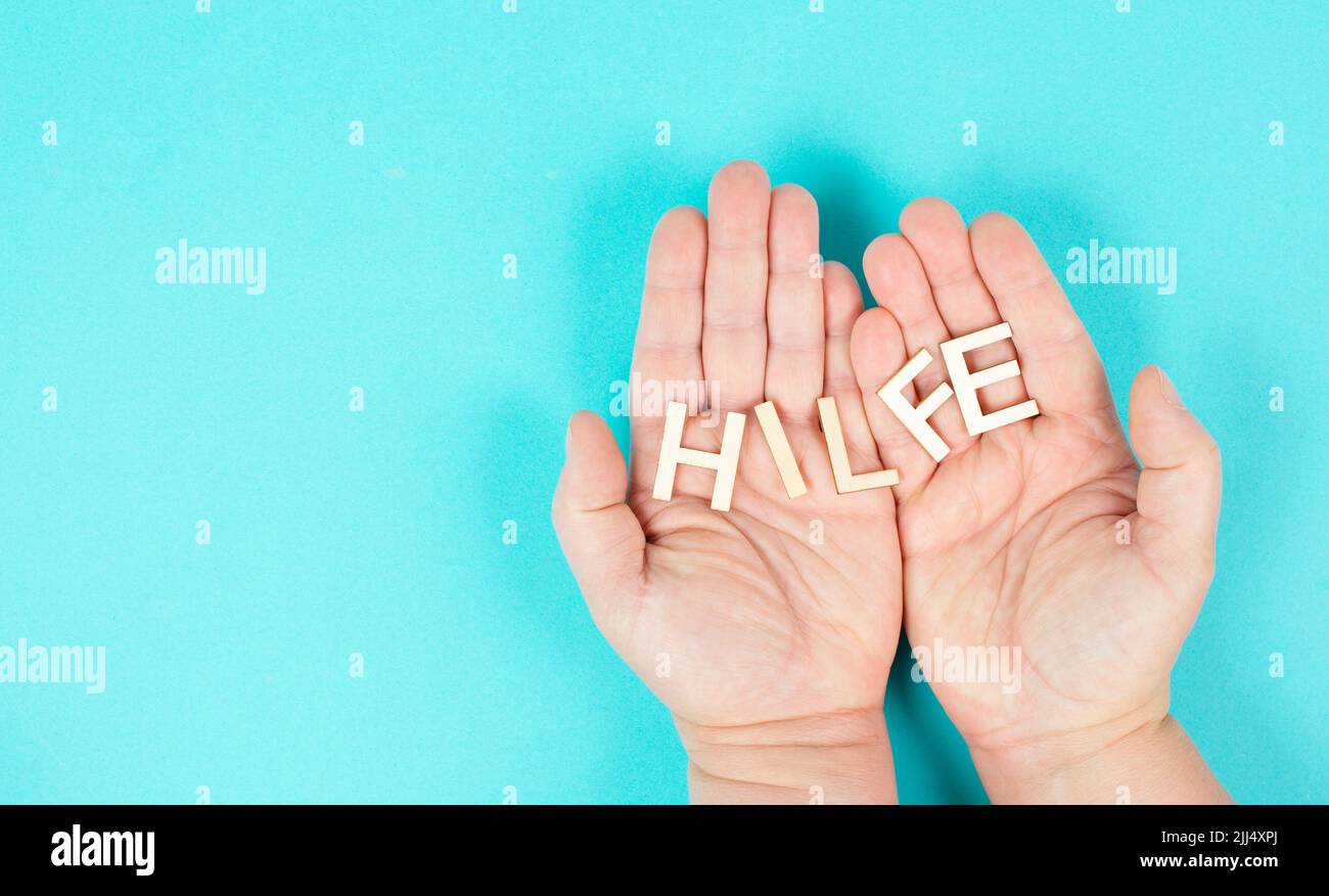 Holding the word help in the hands, german language, giving support and ...