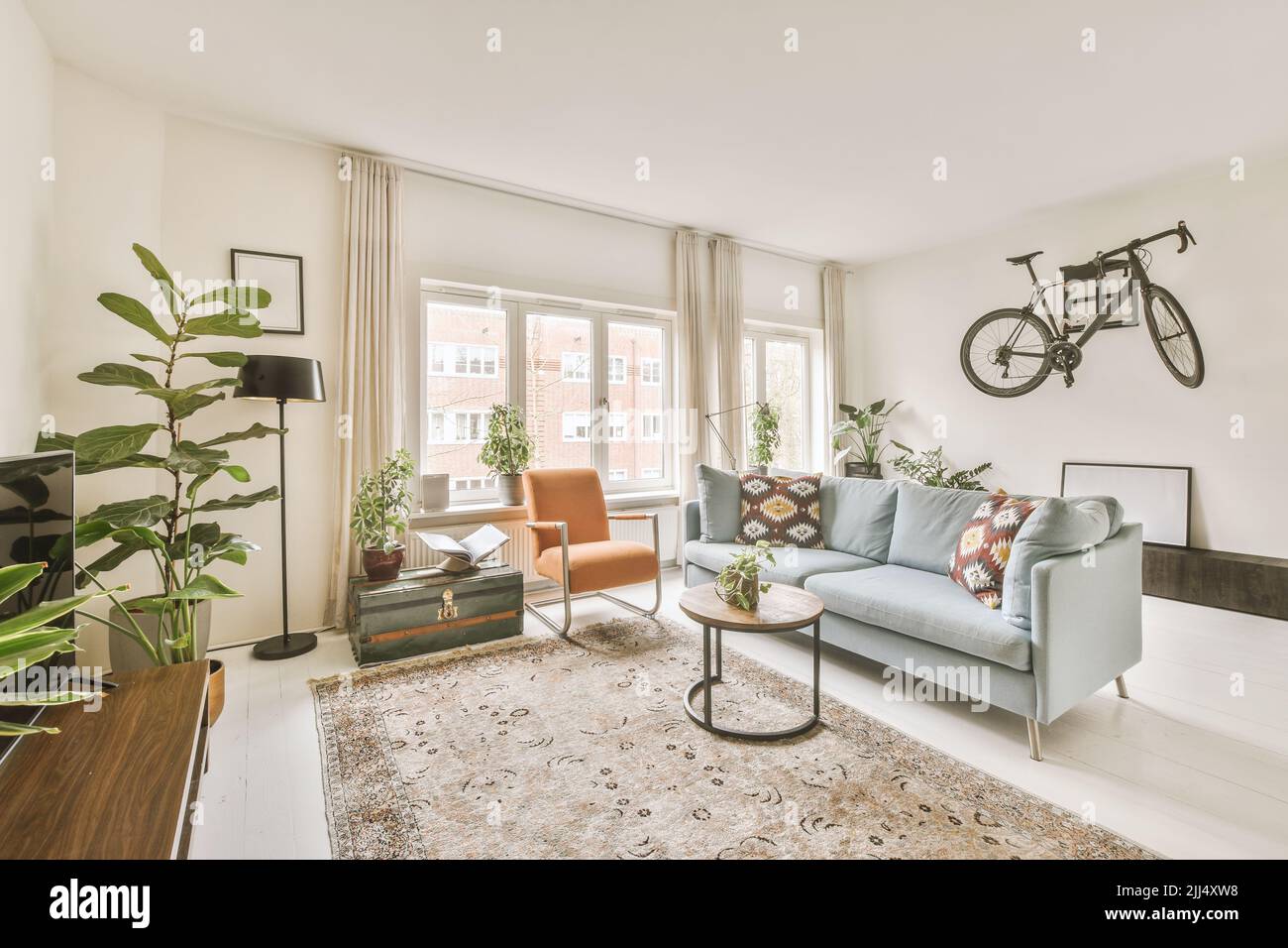 Interior of living room with comfortable sofa and TV against windows in ...