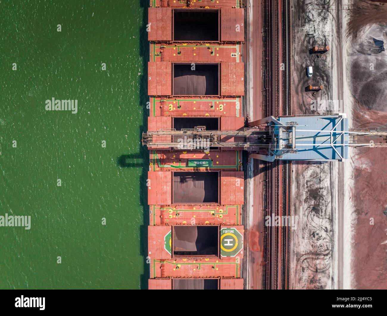 Bulk Carrier Ship Unloading Cargo by Crane at Port Stock Photo - Alamy