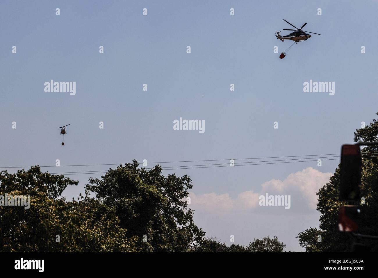 A Slovenian and Serbian helicopters take turns dropping water on a ...