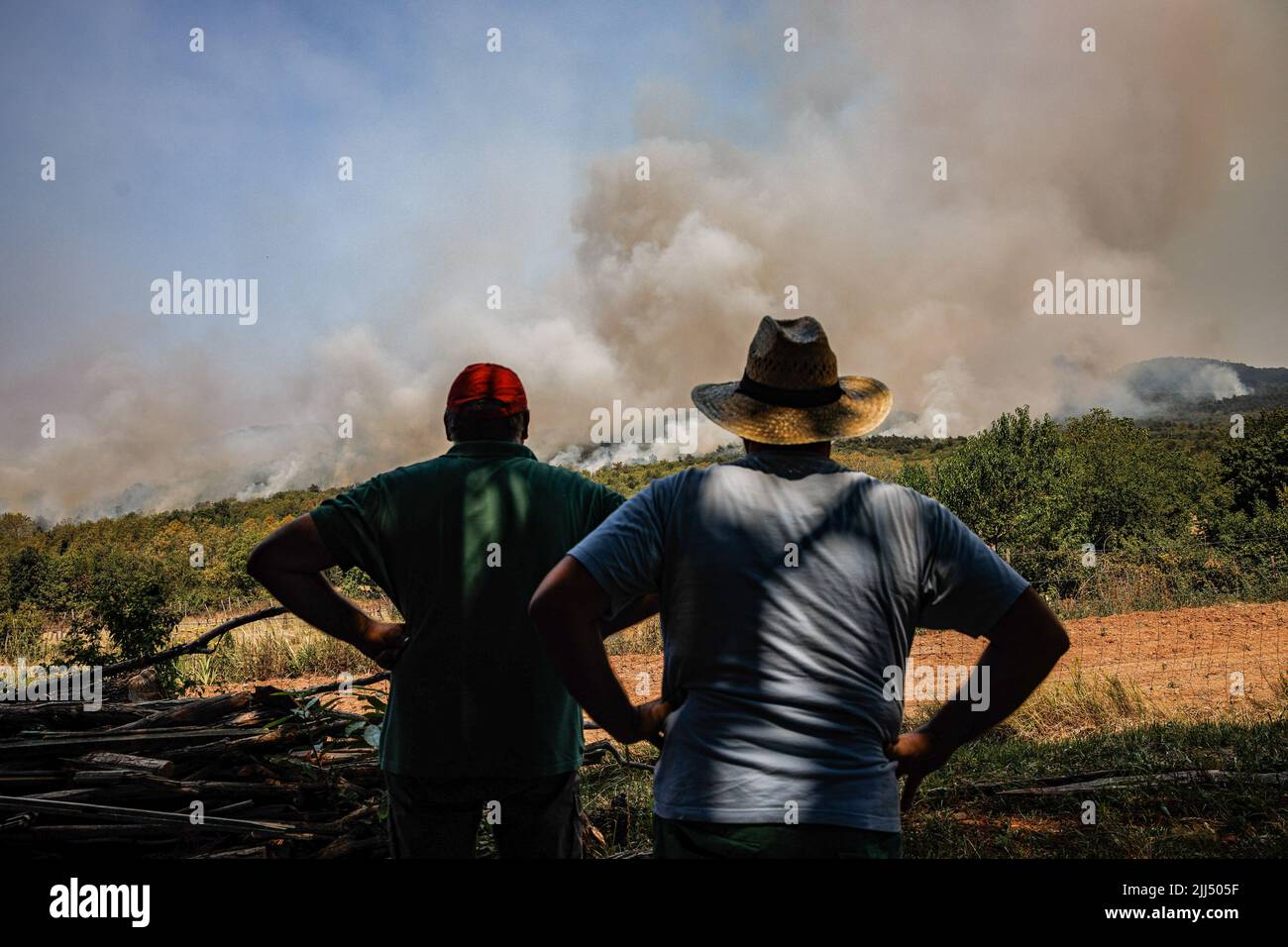Locals watch a large wildfire burn near the village of Novelo in the ...