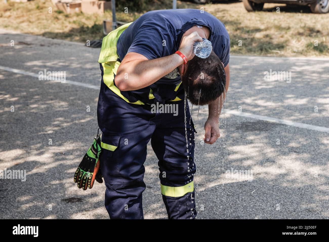 A heat-exhausted fireman douses his head with water as temperatures in ...