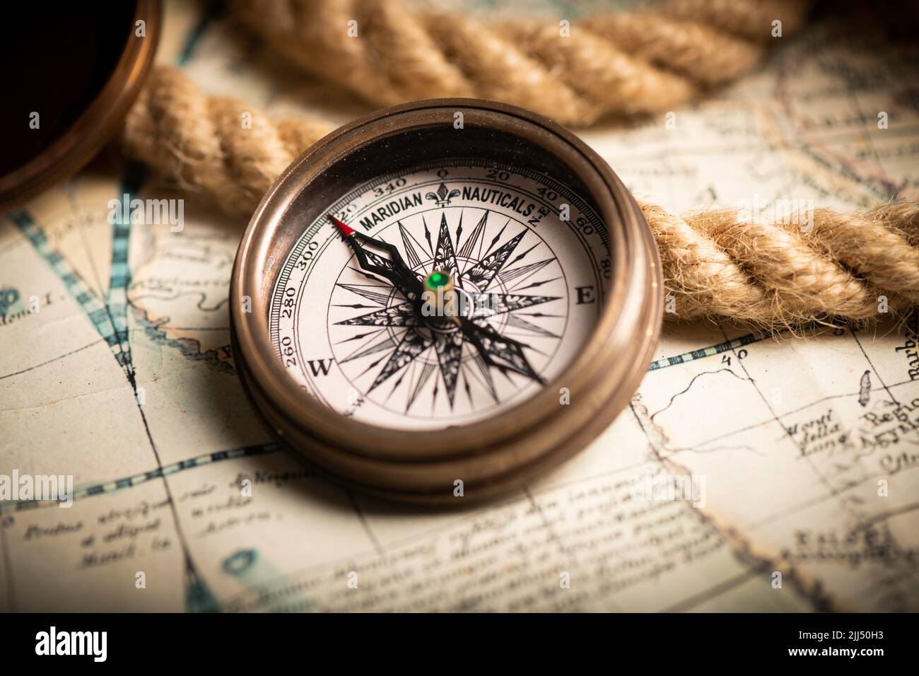 Antique compass lying on old style map close up Stock Photo - Alamy