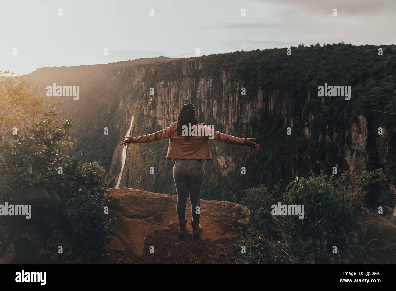 Young woman standing on the cliff at sunset Stock Photo - Alamy
