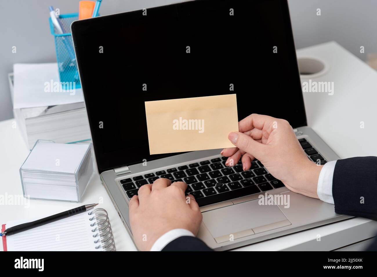 Businesswoman Typing On Lap Top Keyboard And Holding Note With ...