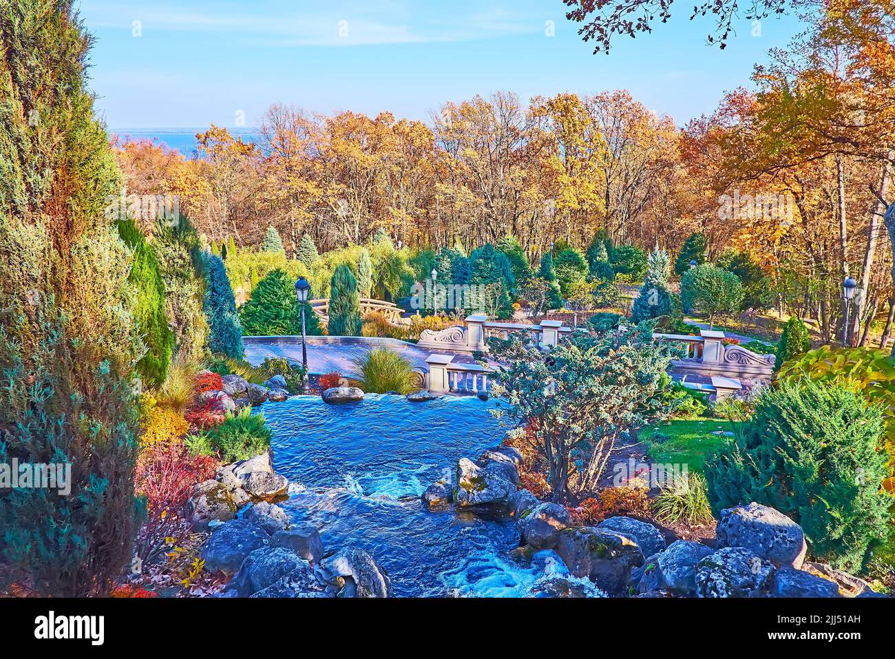The gentle slope, covered with lush conifer plants, colored bushes ...
