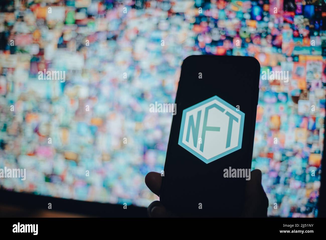Hand holding a mobile phone showing an NFT Stock Photo - Alamy