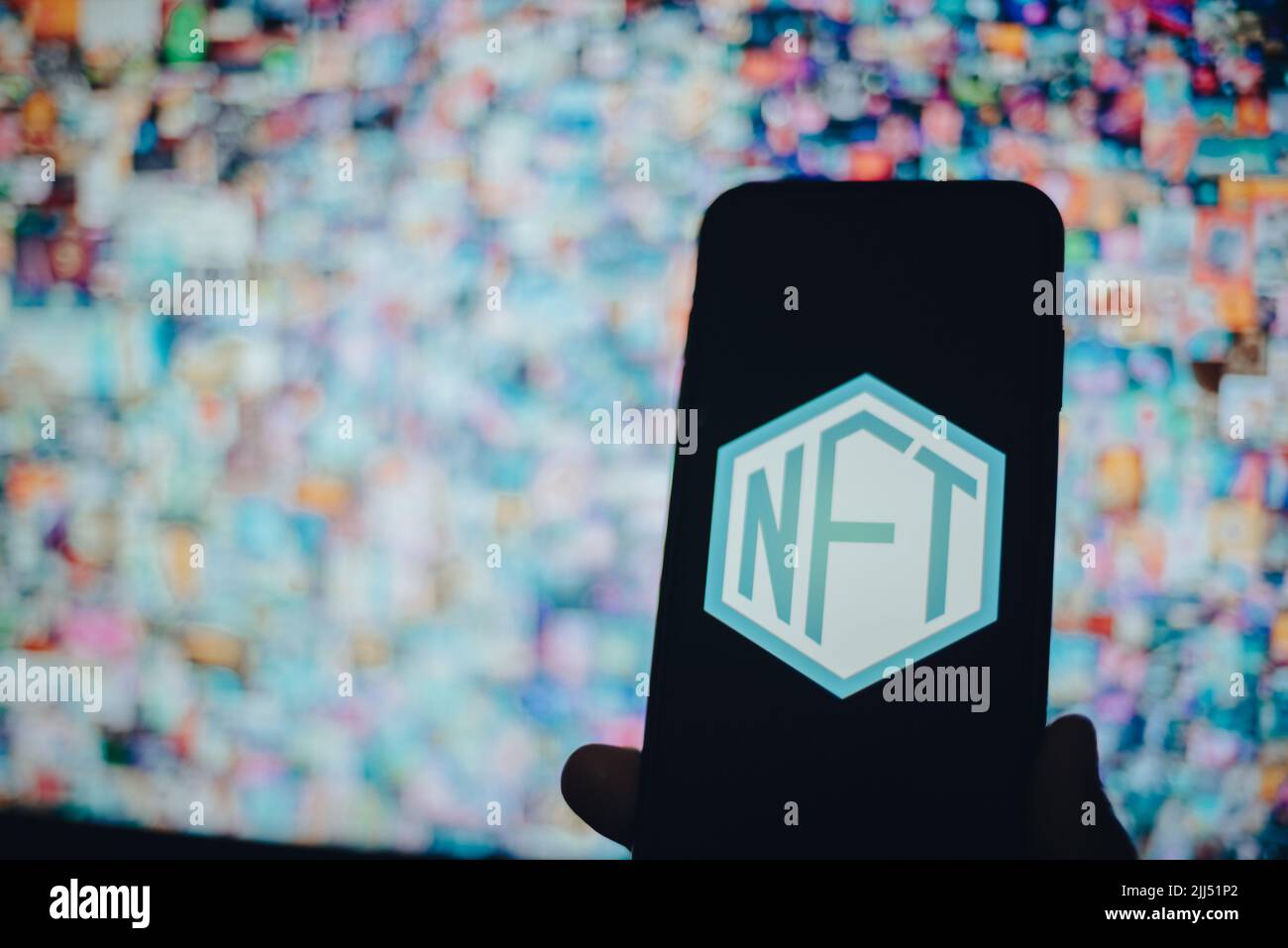 Hand holding a mobile phone showing an NFT Stock Photo - Alamy
