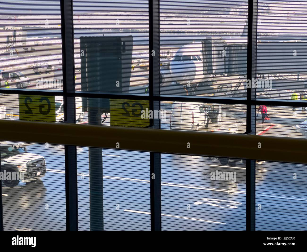 Looking through airport window on airplane connected to extension of ...