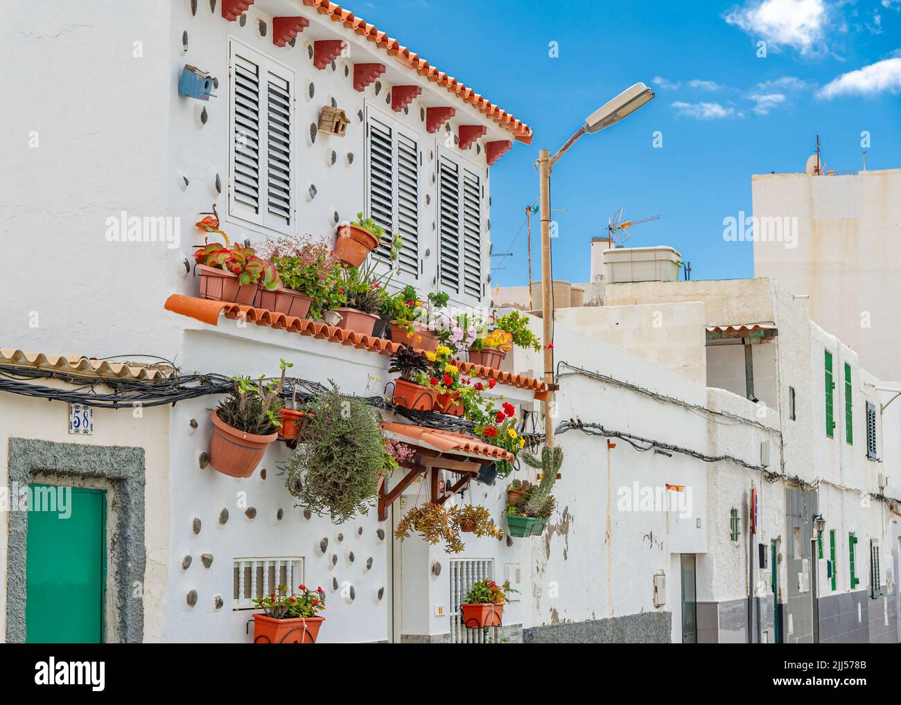 Narrow streets adorned with flowers on balconies and very large flower ...