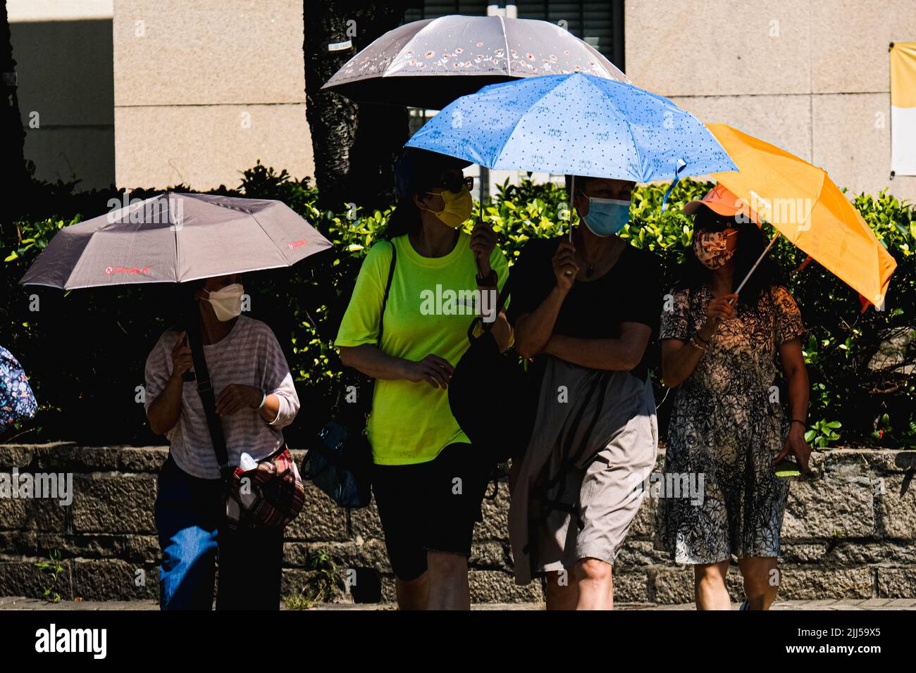 Hong Kong, China. 23rd July, 2022. People cross a street with face mask ...