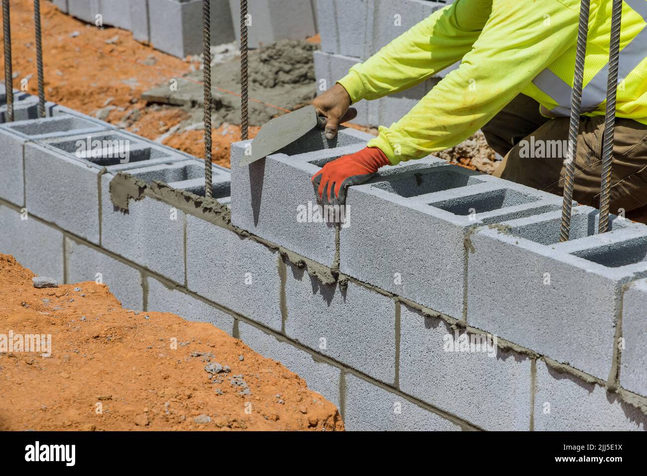 This mason installing a wall of aerated concrete blocks around him ...