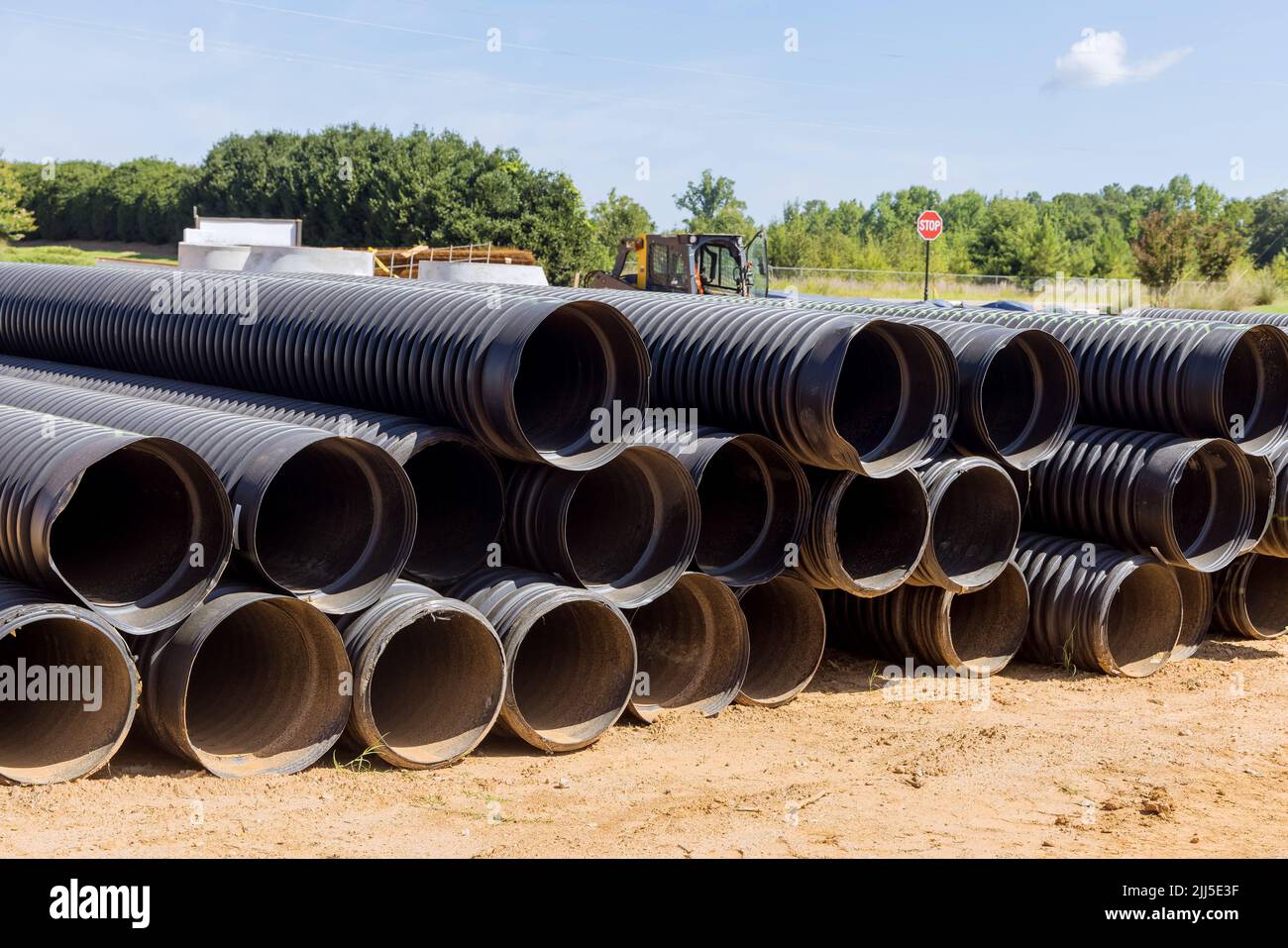 In the construction site, new PVC black plastic pipes stacked in rows ...