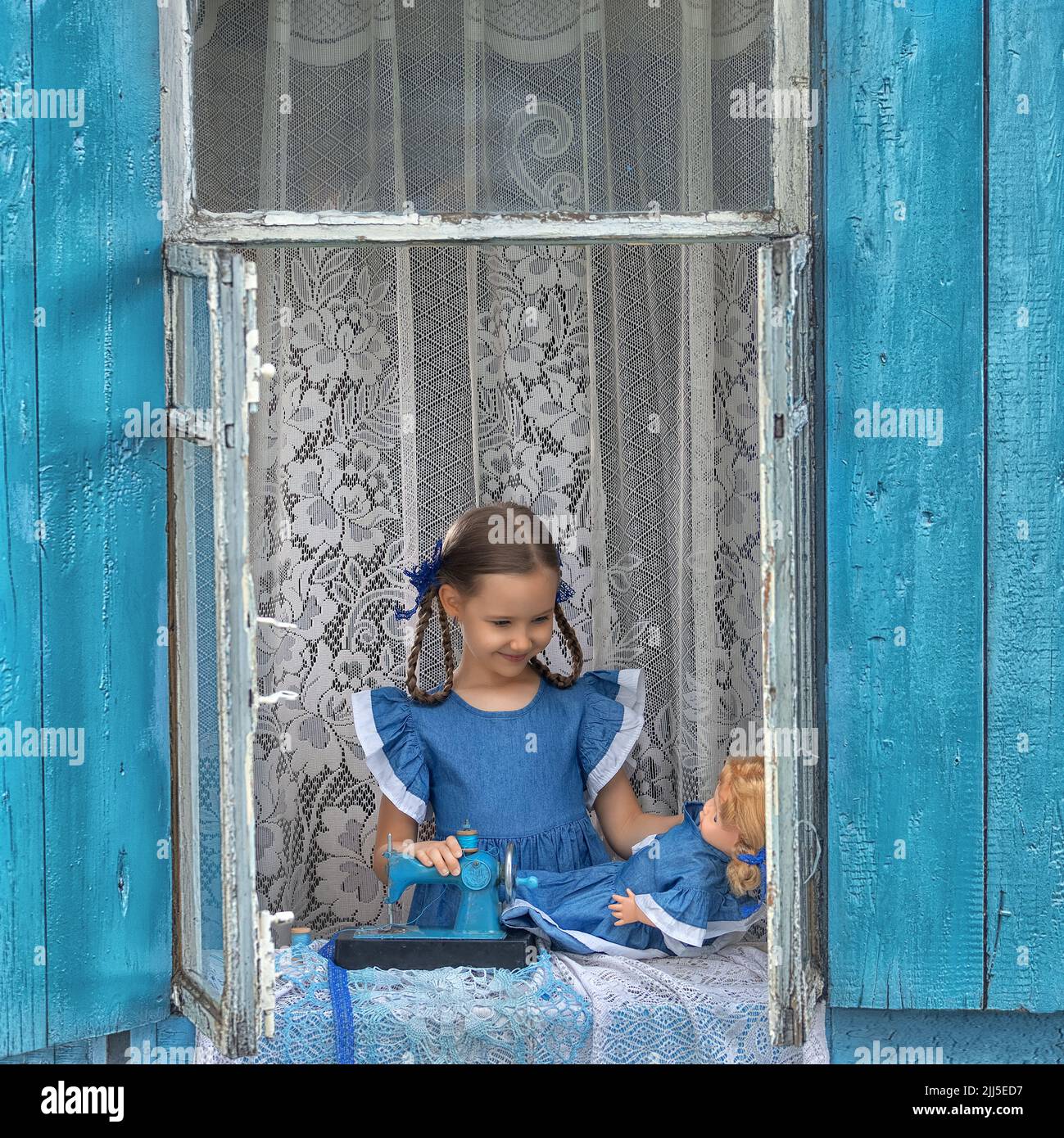 Portrait of girl kid tailor sew making doll's clothes on a children's ...