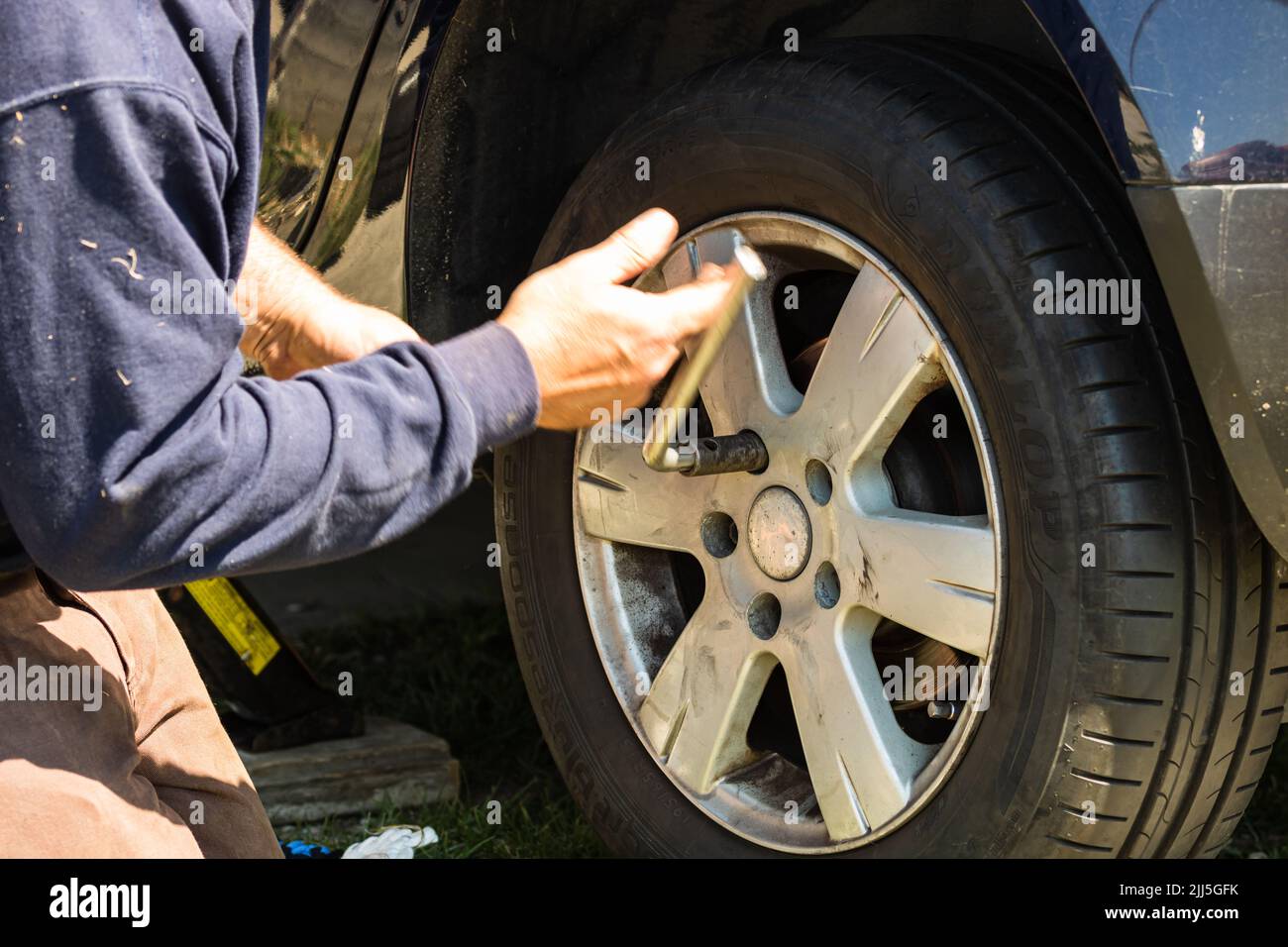 Car mechanic screwing or unscrewing car wheel by wrench at car garage ...
