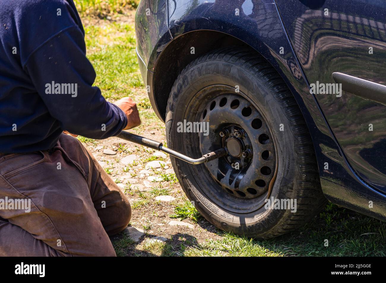 Car mechanic screwing or unscrewing car wheel by wrench at car garage ...