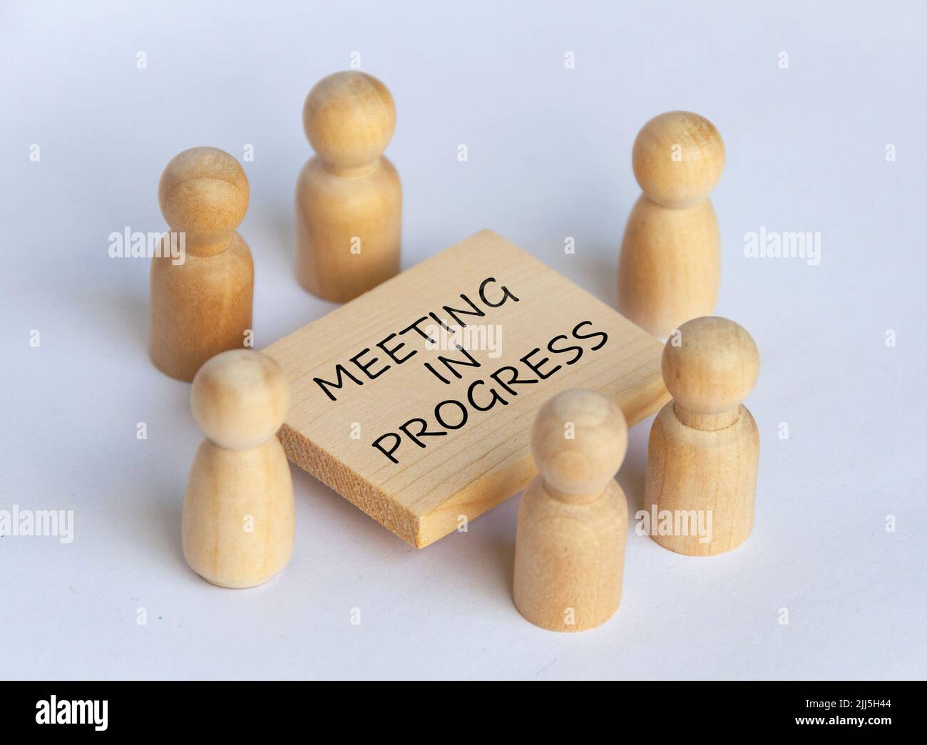 Wooden people figures having business meeting with meeting in progress ...