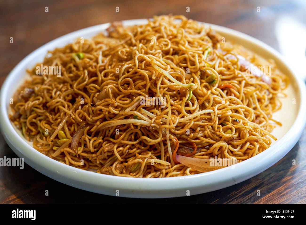 A Plate Of Delicious Hong Kong Style Fried Noodles With Soy Sauce Stock