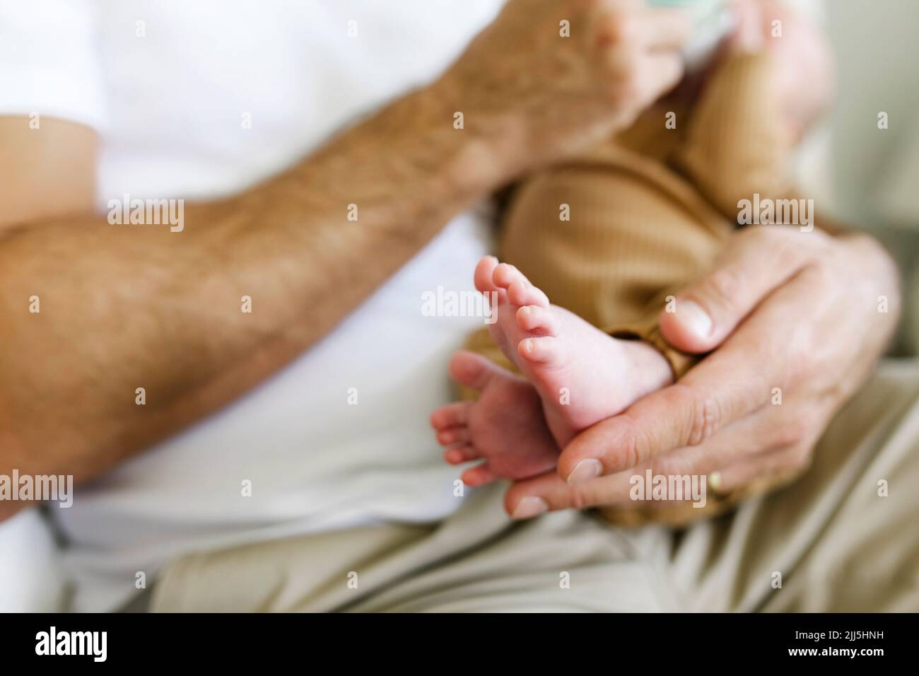 Hand of man carrying baby at home Stock Photo - Alamy