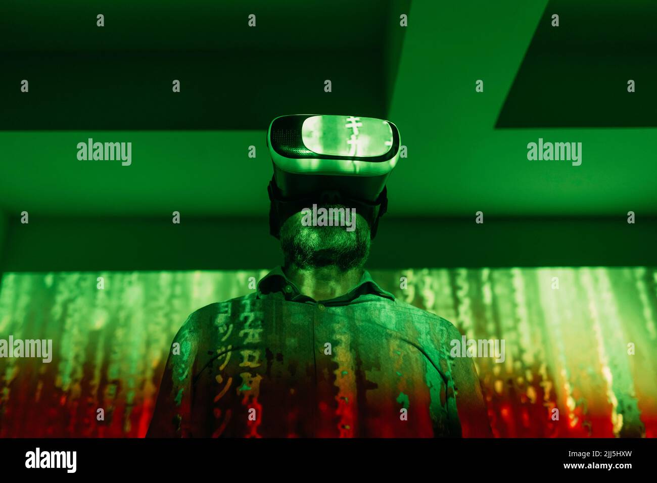 Man wearing virtual reality simulator in front of falling digital code ...