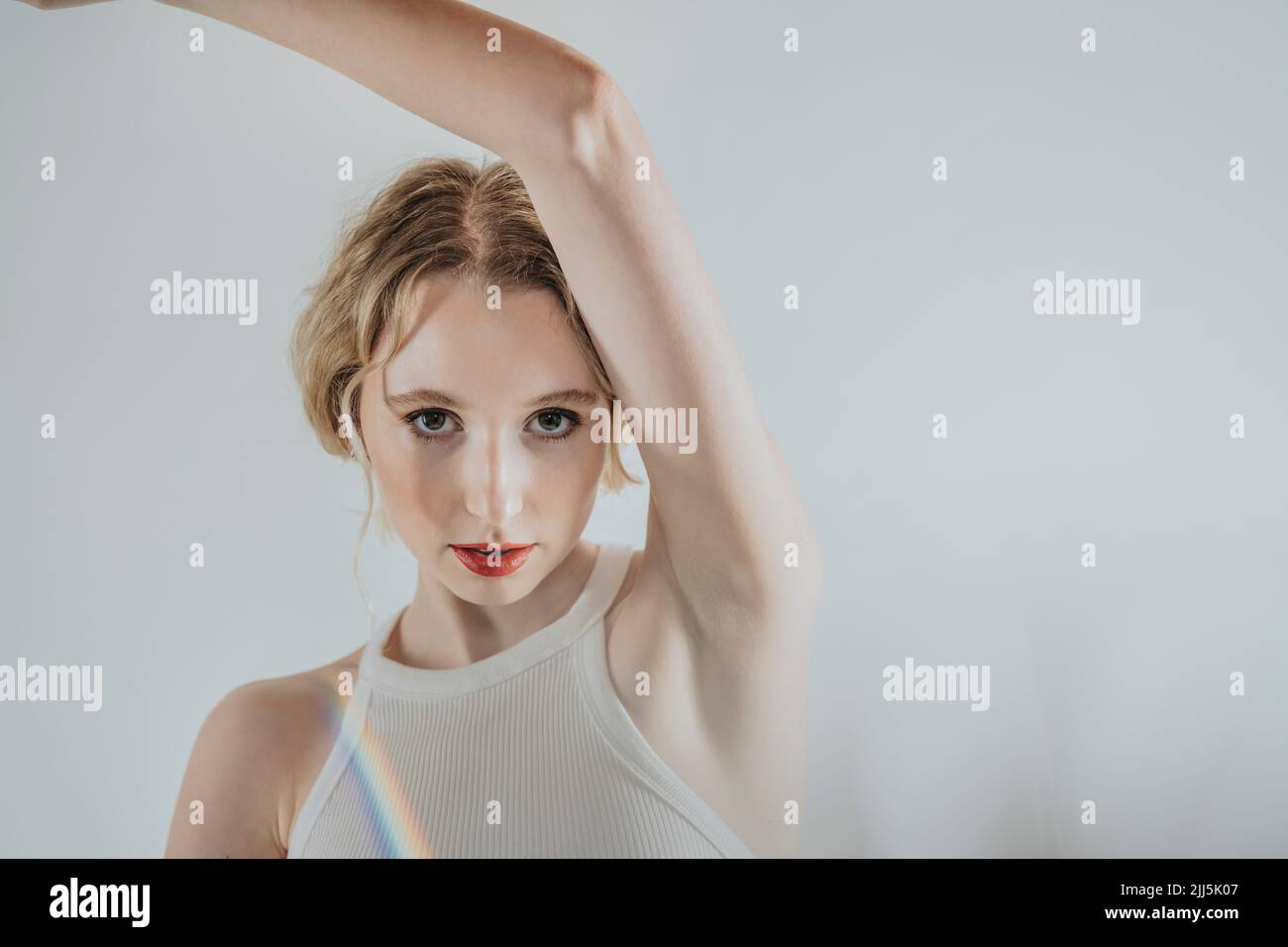 Confident woman showing armpit against white background Stock Photo - Alamy