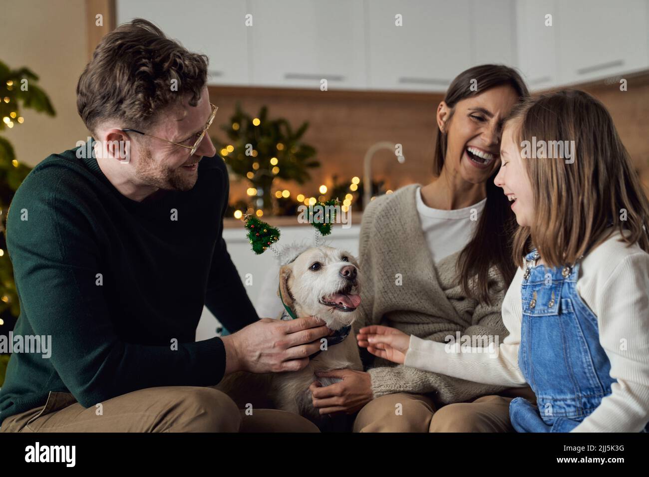 Happy family with dog enjoying Christmas time together at home Stock ...