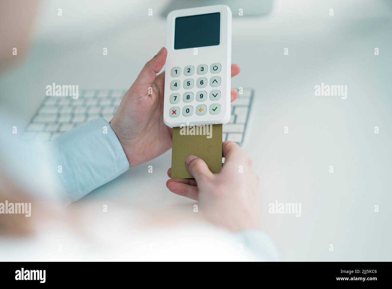 Hands of woman paying through credit card at office Stock Photo - Alamy