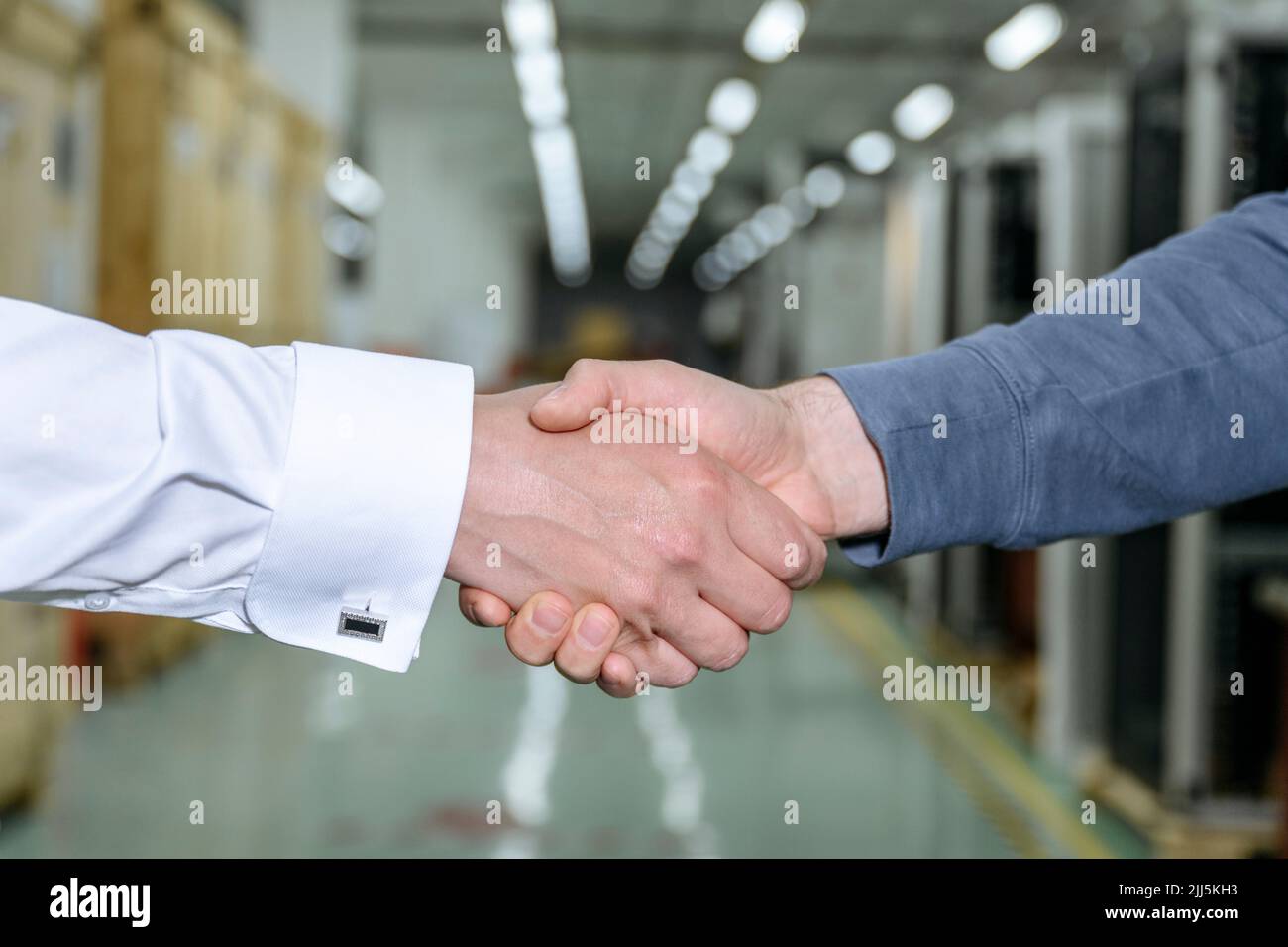 Businessman shaking hands with colleague in factory Stock Photo - Alamy