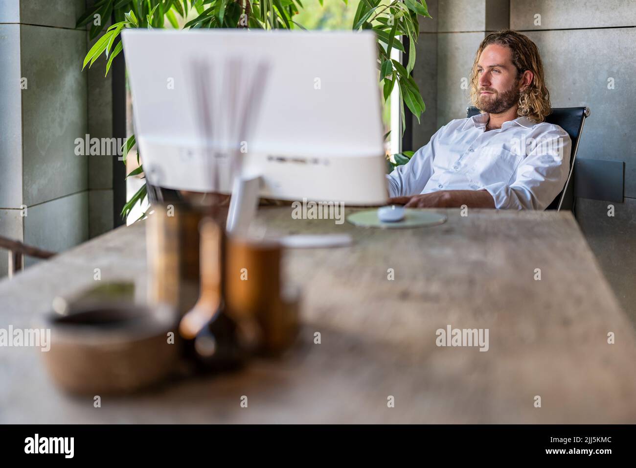 Thoughtful executive sitting on chair at table in office Stock Photo ...