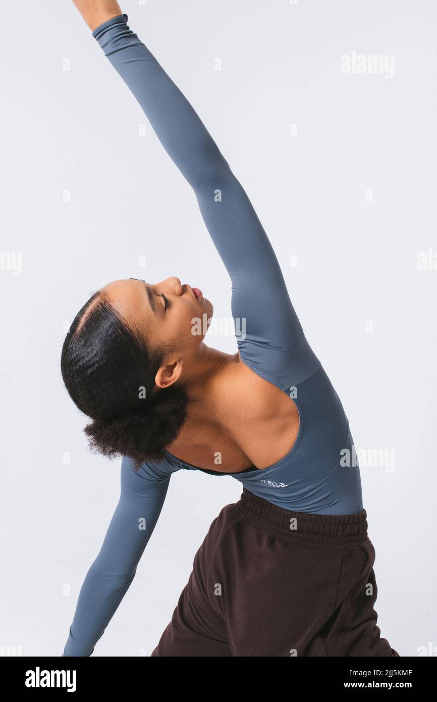 Ballet dancer with hand raised dancing against white background Stock ...
