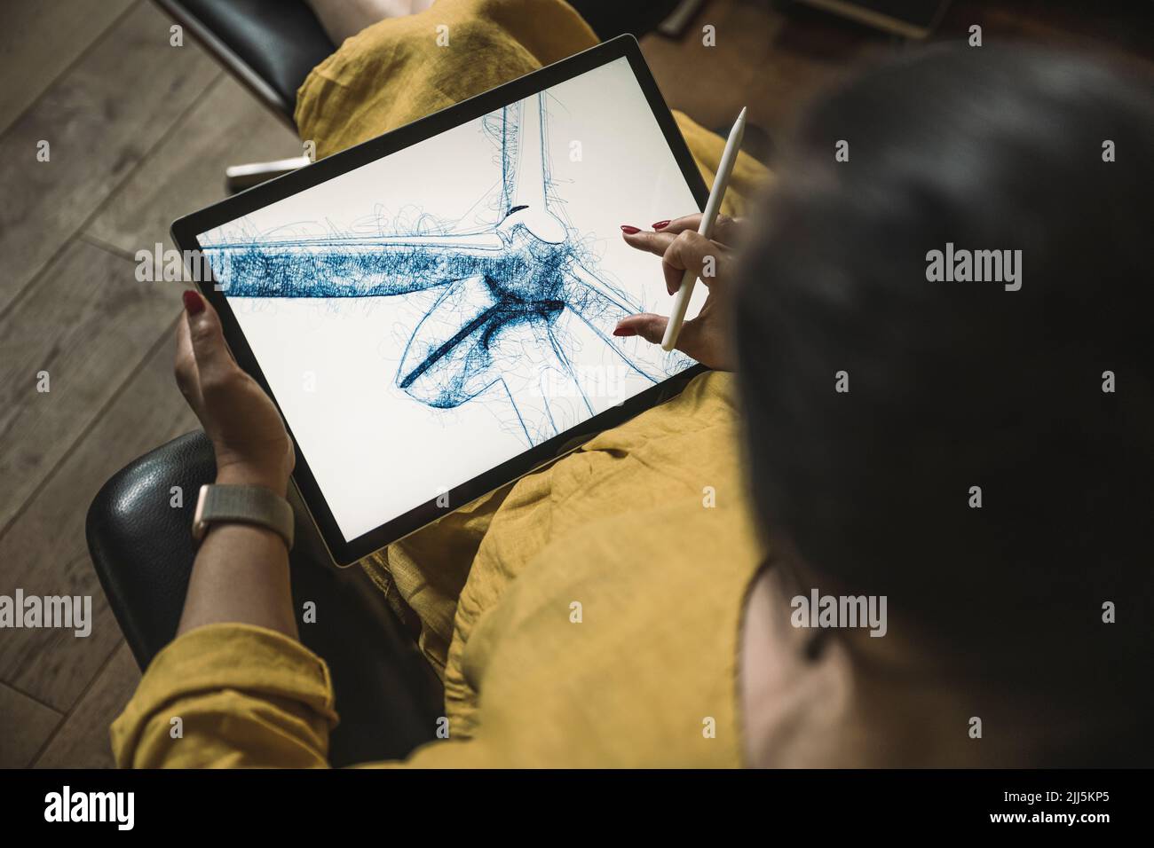 Engineer pinching design of wind turbine on graphics tablet at home ...