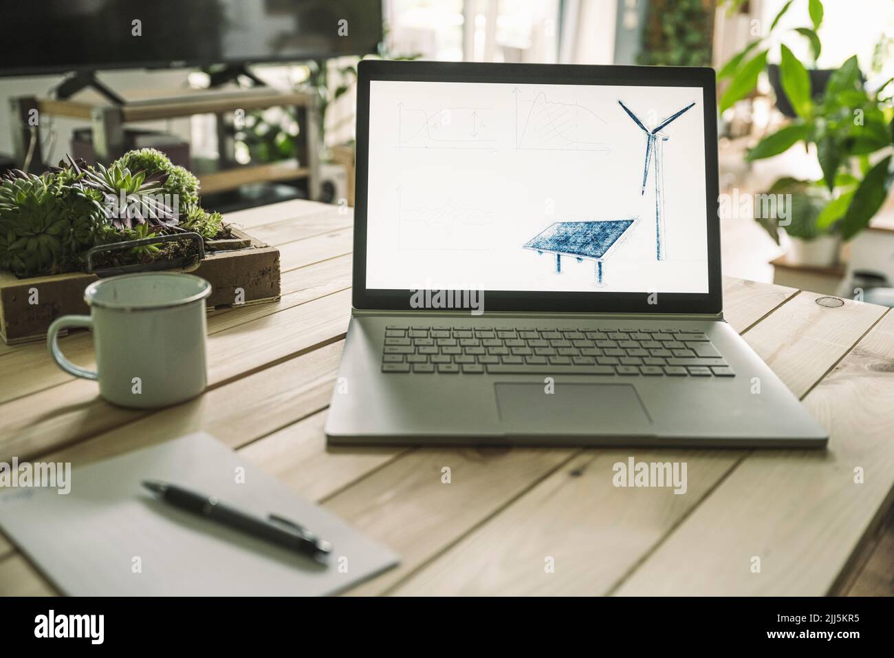 Solar panel and wind turbine on screen of laptop at home Stock Photo ...