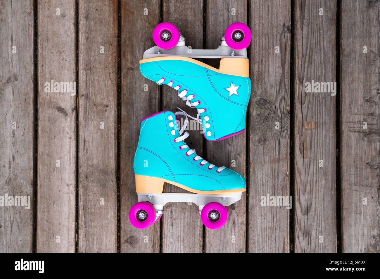 Multi colored roller skates on floorboard Stock Photo - Alamy