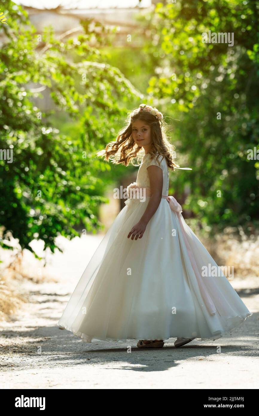 Smiling girl wearing communion dress on footpath Stock Photo - Alamy