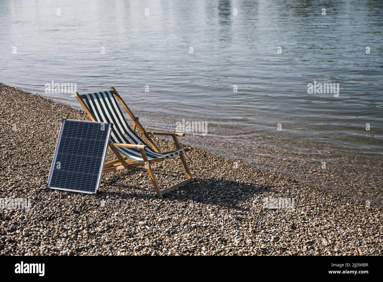 Solar panel and deck chair at riverbank on sunny day Stock Photo - Alamy