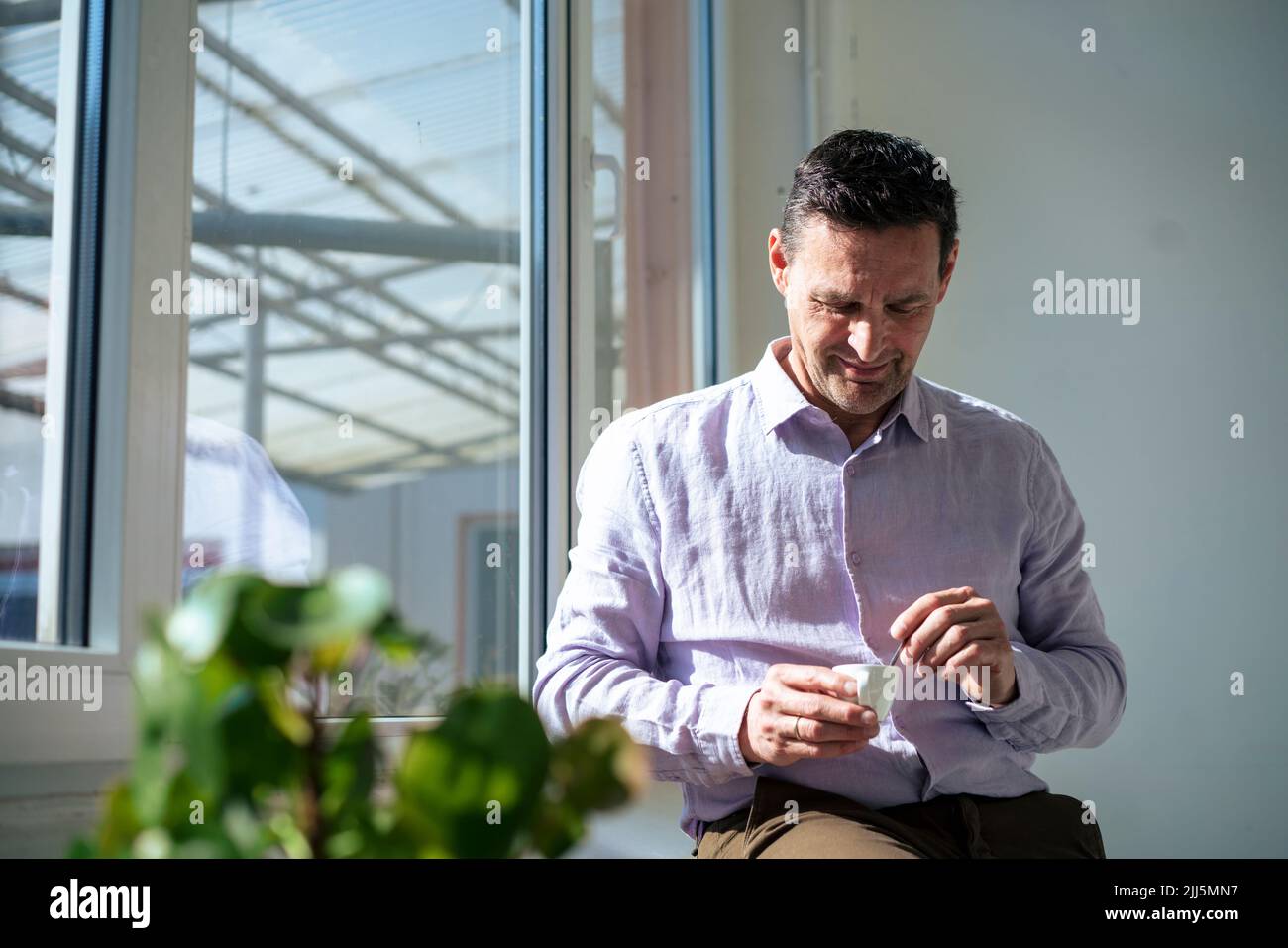Man seated office window holding hi-res stock photography and images ...