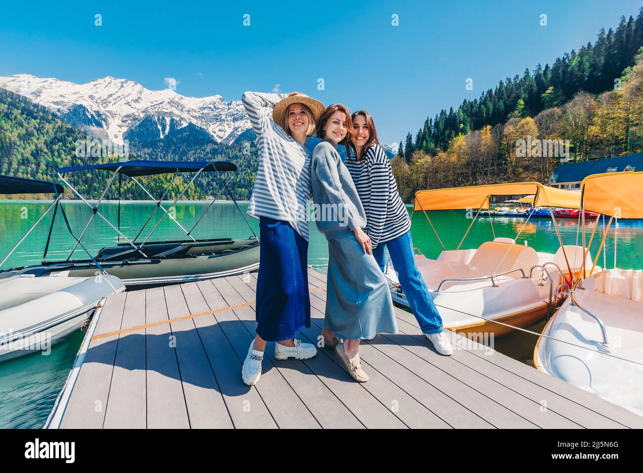 Friends posing together on jetty at Lake Ritsa Stock Photo - Alamy