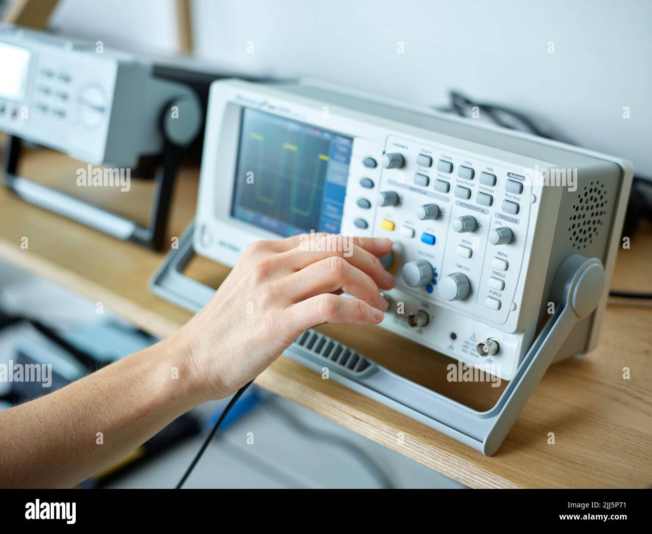 Hand of engineer adjusting oscilloscope in electronic laboratory Stock ...