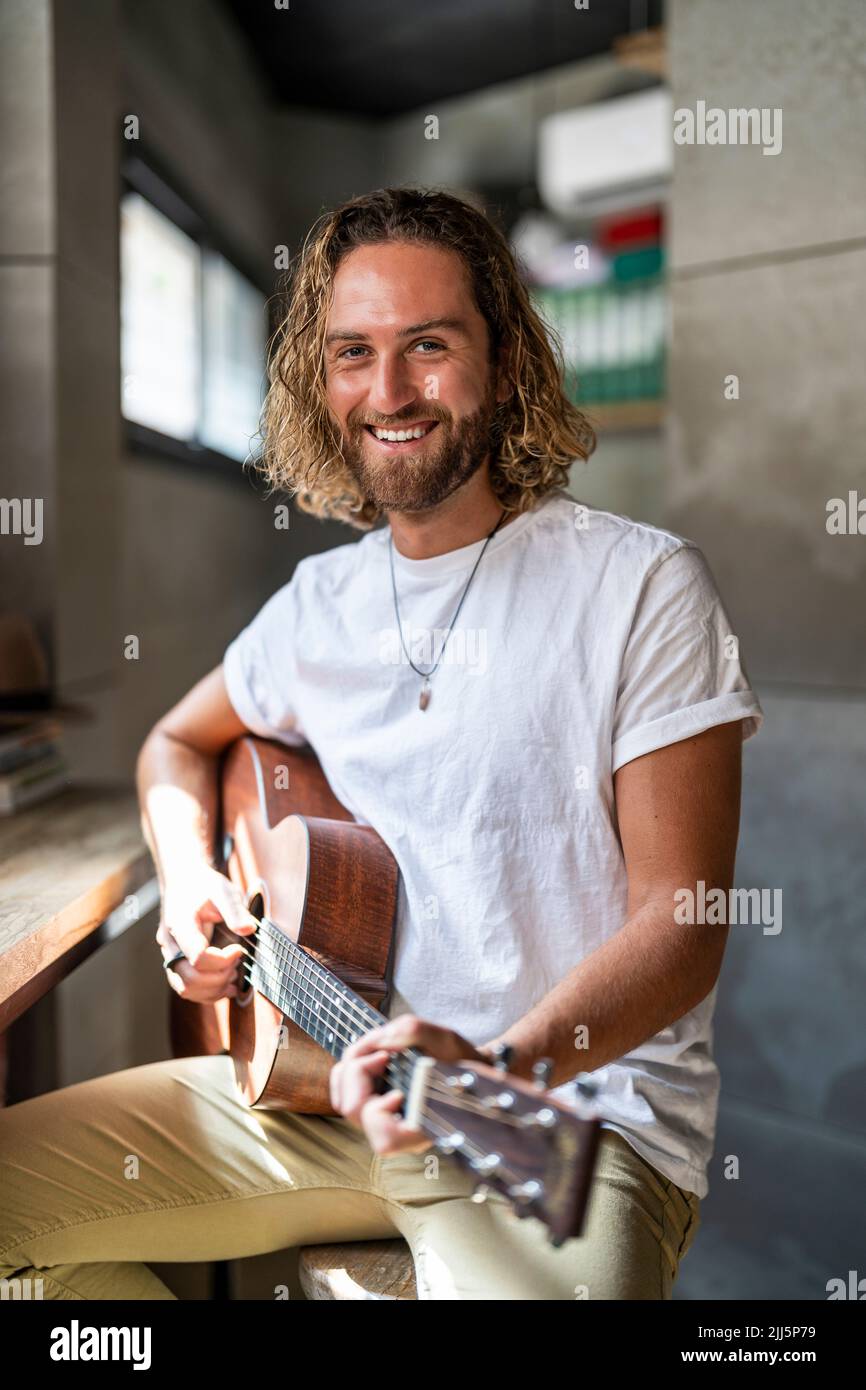 Smiling guitarist playing guitar at home Stock Photo - Alamy