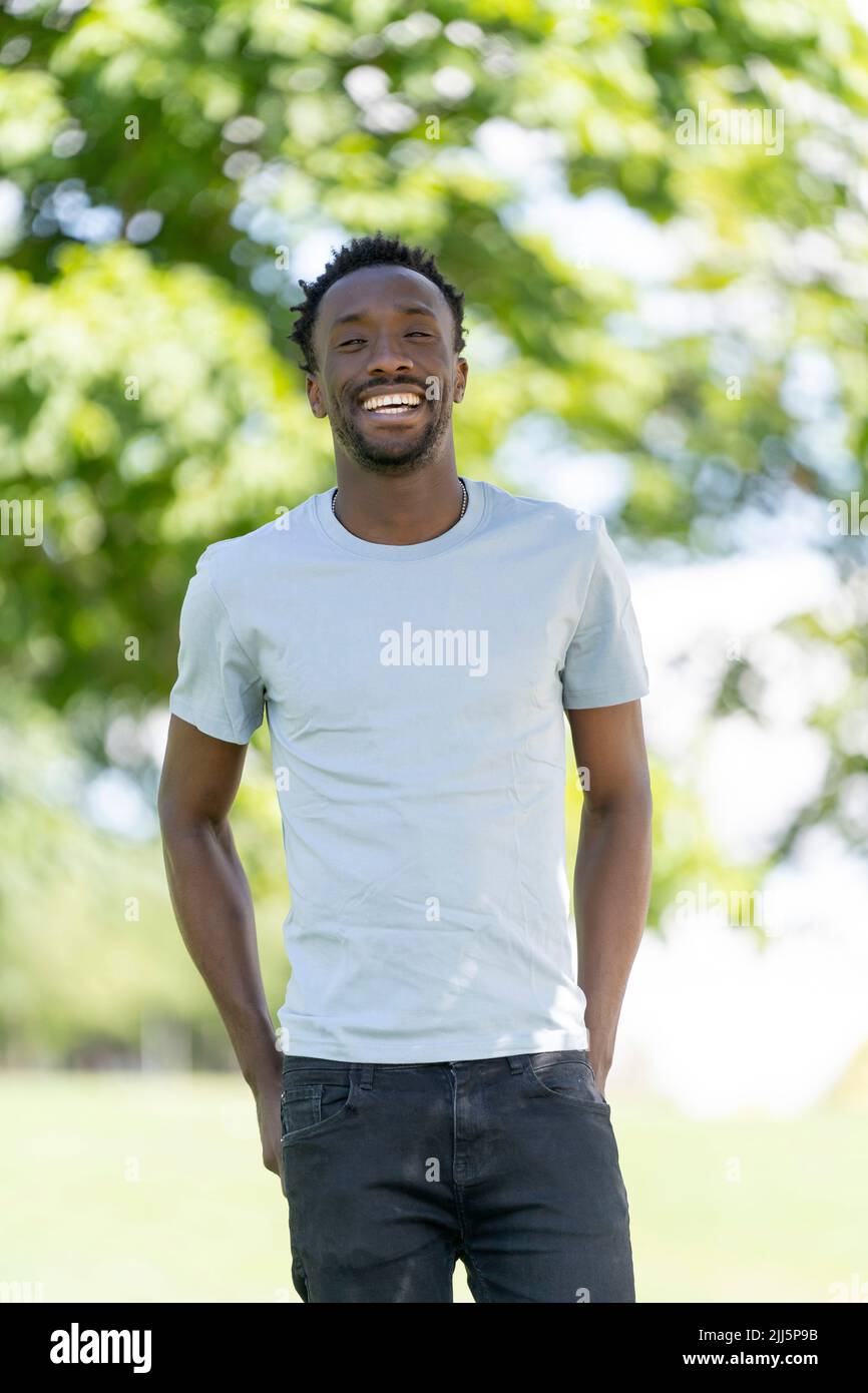 Happy young man standing in park Stock Photo - Alamy