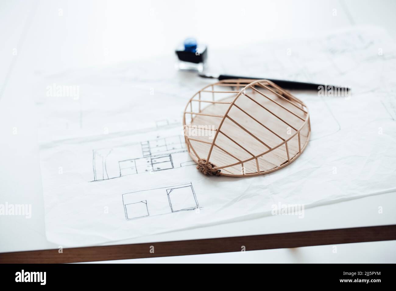Architectural model over blueprint on desk in office Stock Photo - Alamy