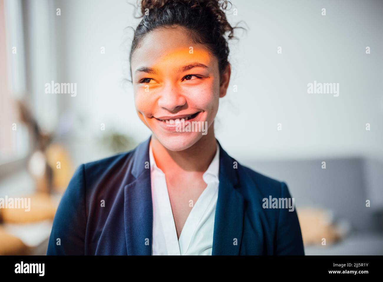 Smiling young businesswoman standing in office Stock Photo - Alamy