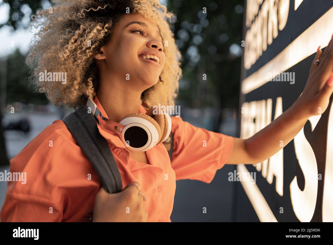 Happy young woman touching illuminated banner Stock Photo - Alamy