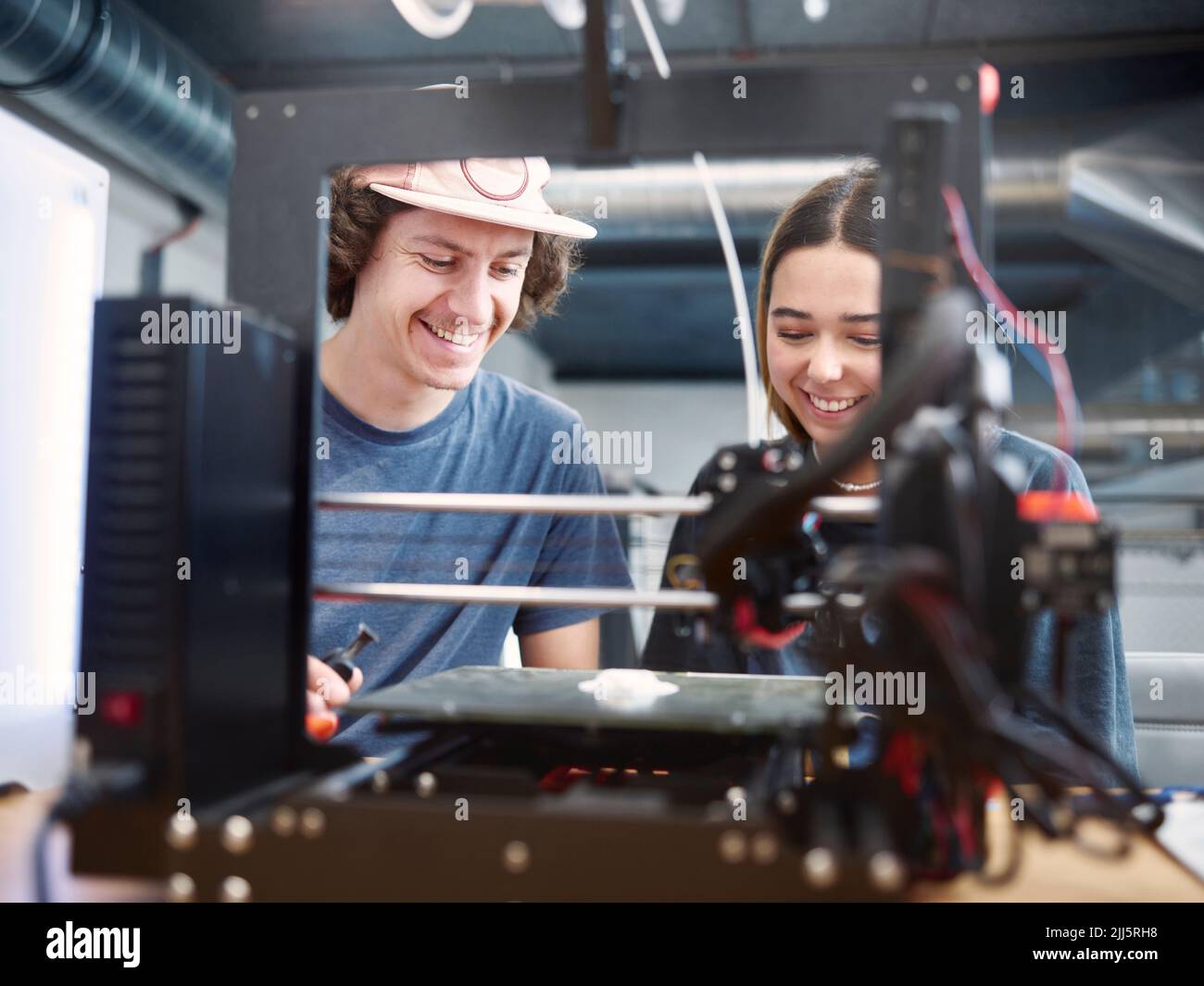 Smiling engineers working with 3d printer at workshop Stock Photo - Alamy
