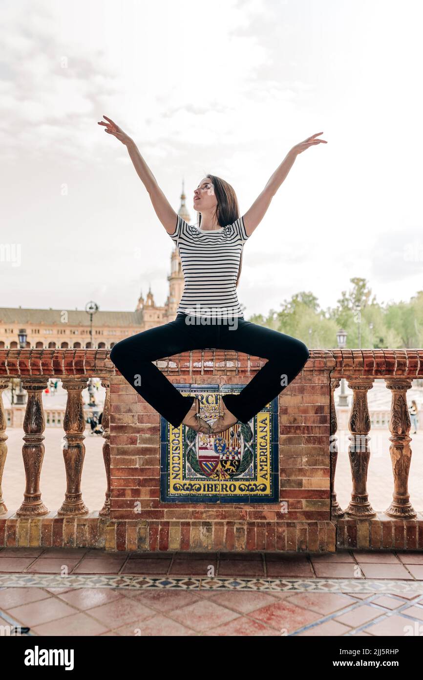 Ballet dancer with arms raised sitting on historic Stock Photo - Alamy