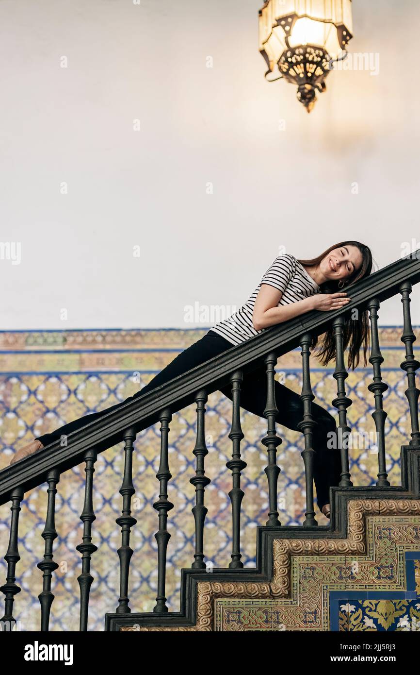 Smiling ballet dancer leaning on railing at staircase Stock Photo - Alamy