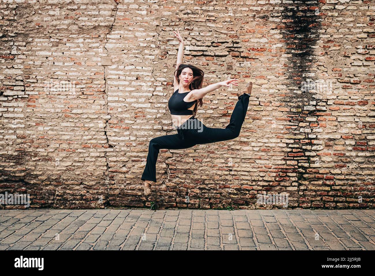 Young ballet dancer dancing in front of brick wall Stock Photo - Alamy