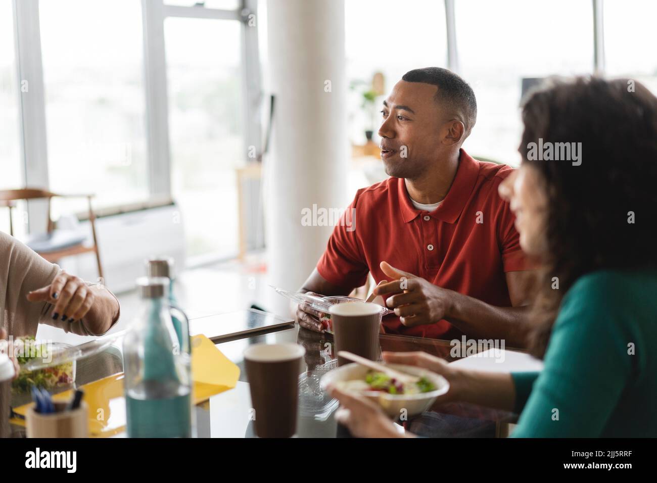 Happy business colleagues having snacks together at desk Stock Photo ...