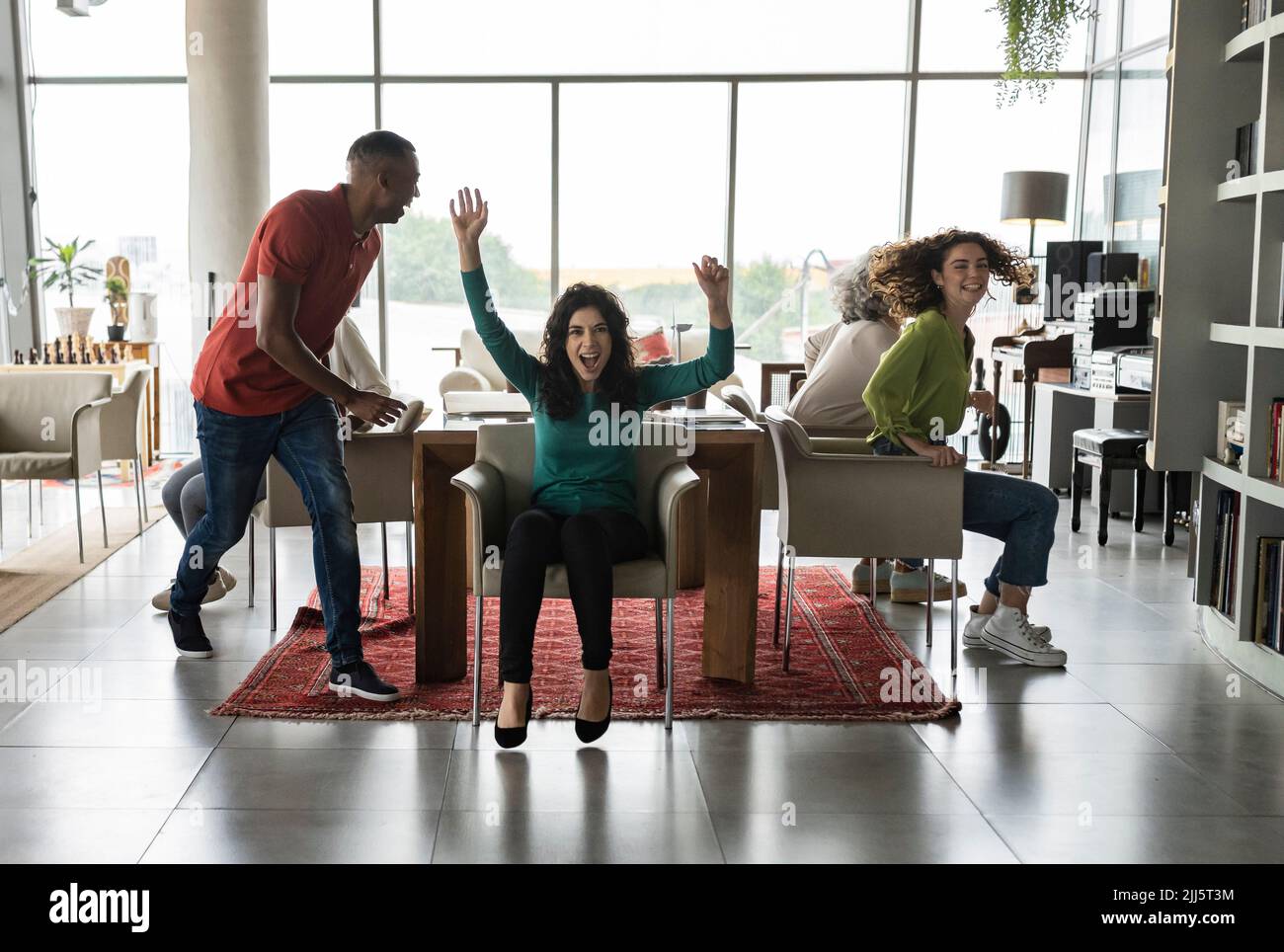 Cheerful business colleagues playing musical chairs in office Stock ...