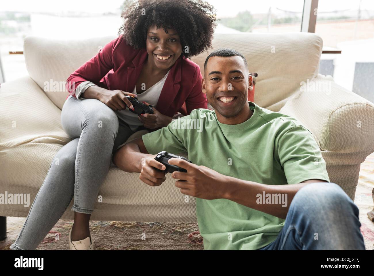 Smiling young woman playing video game with man Stock Photo - Alamy